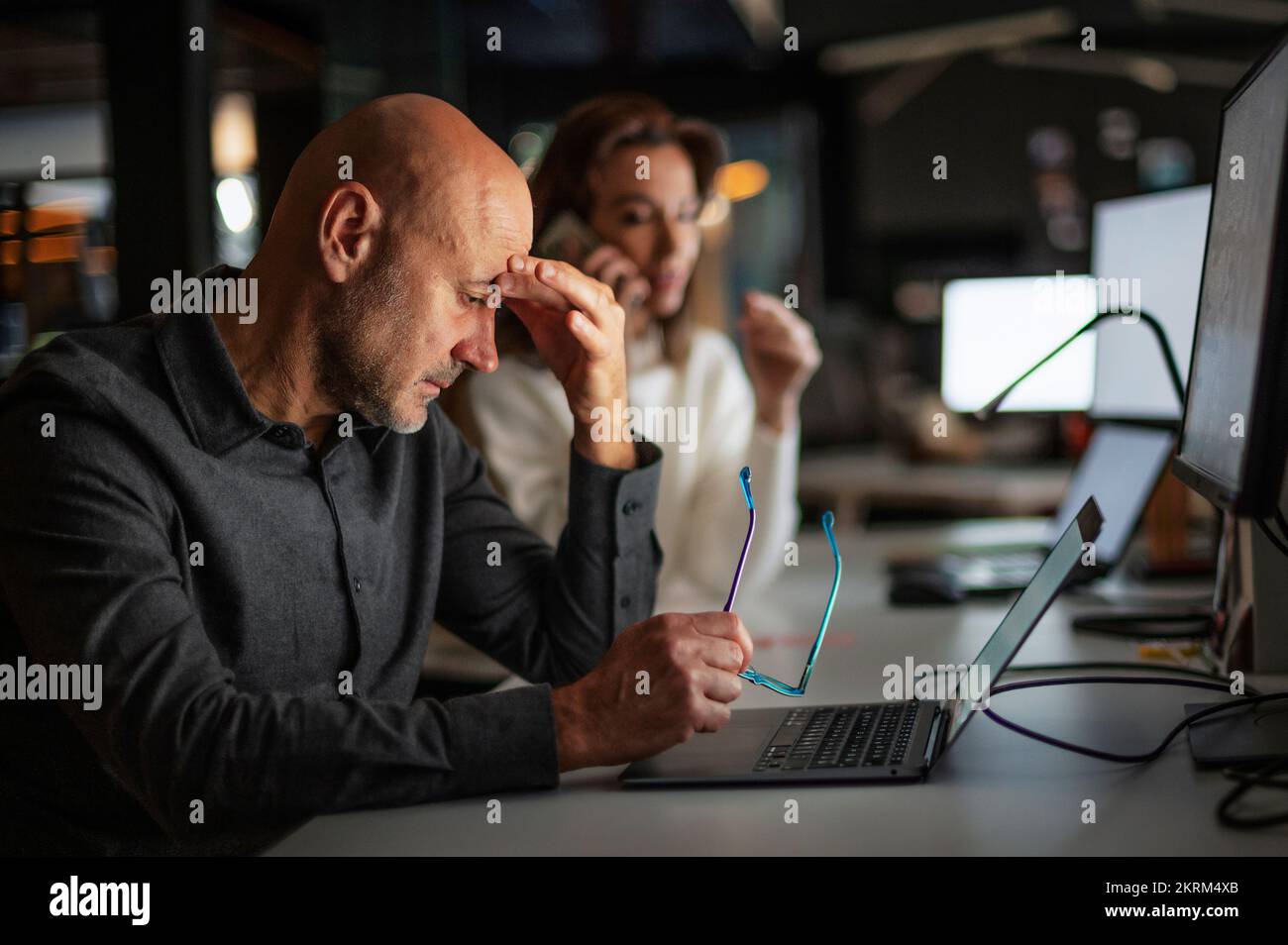 Shot of a businessman looking exhausted while sitting at his desk in ...