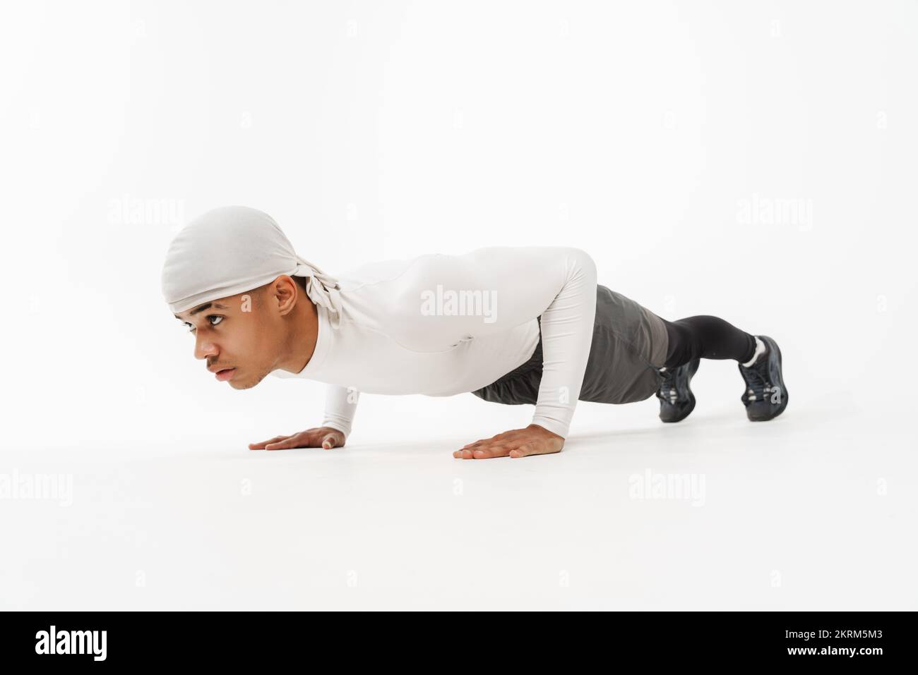 Young sportsman wearing bandana doing exercise while working out ...
