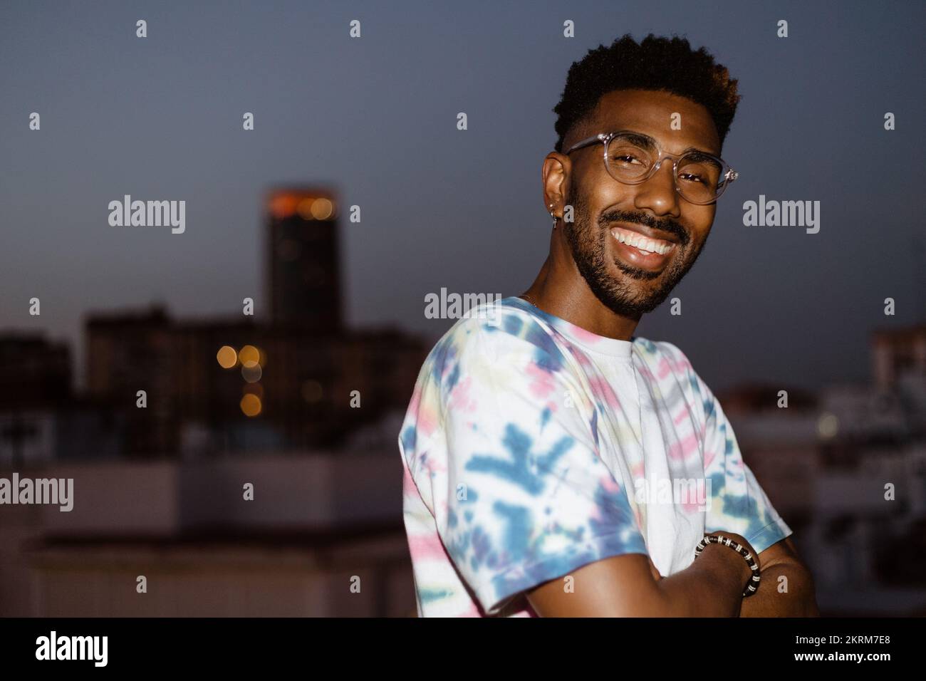 Cheerful African American male in multicolored t shirt and eyeglasses ...
