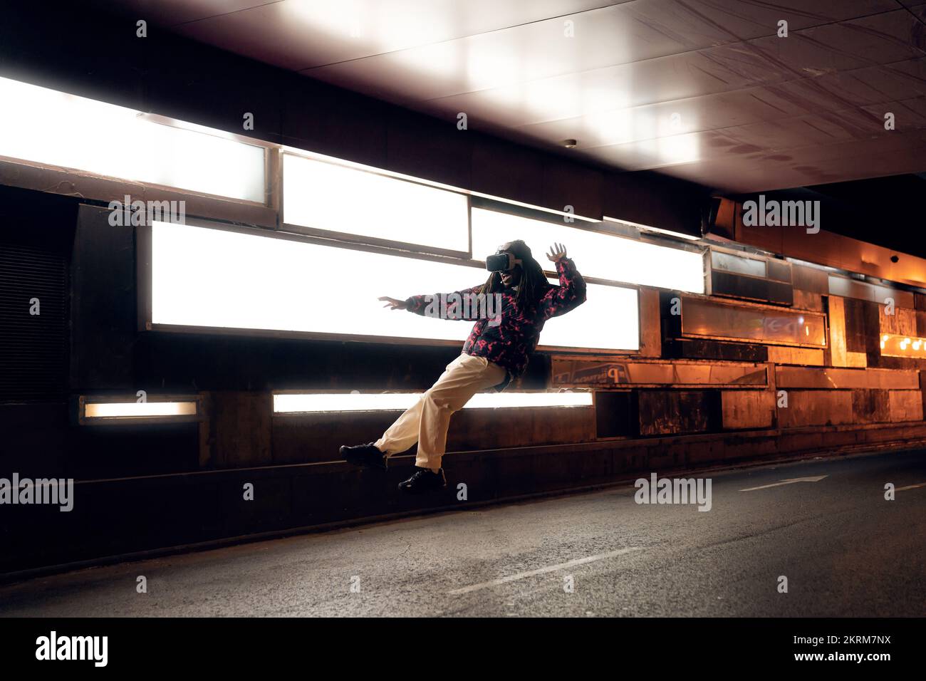 Full body of male in VR goggles levitating above asphalt road near ...
