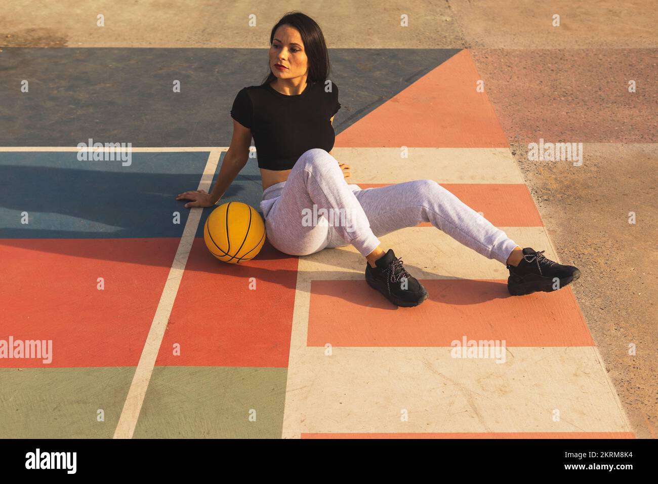 Full body high angle of young sportive woman in sportswear leaning back ...