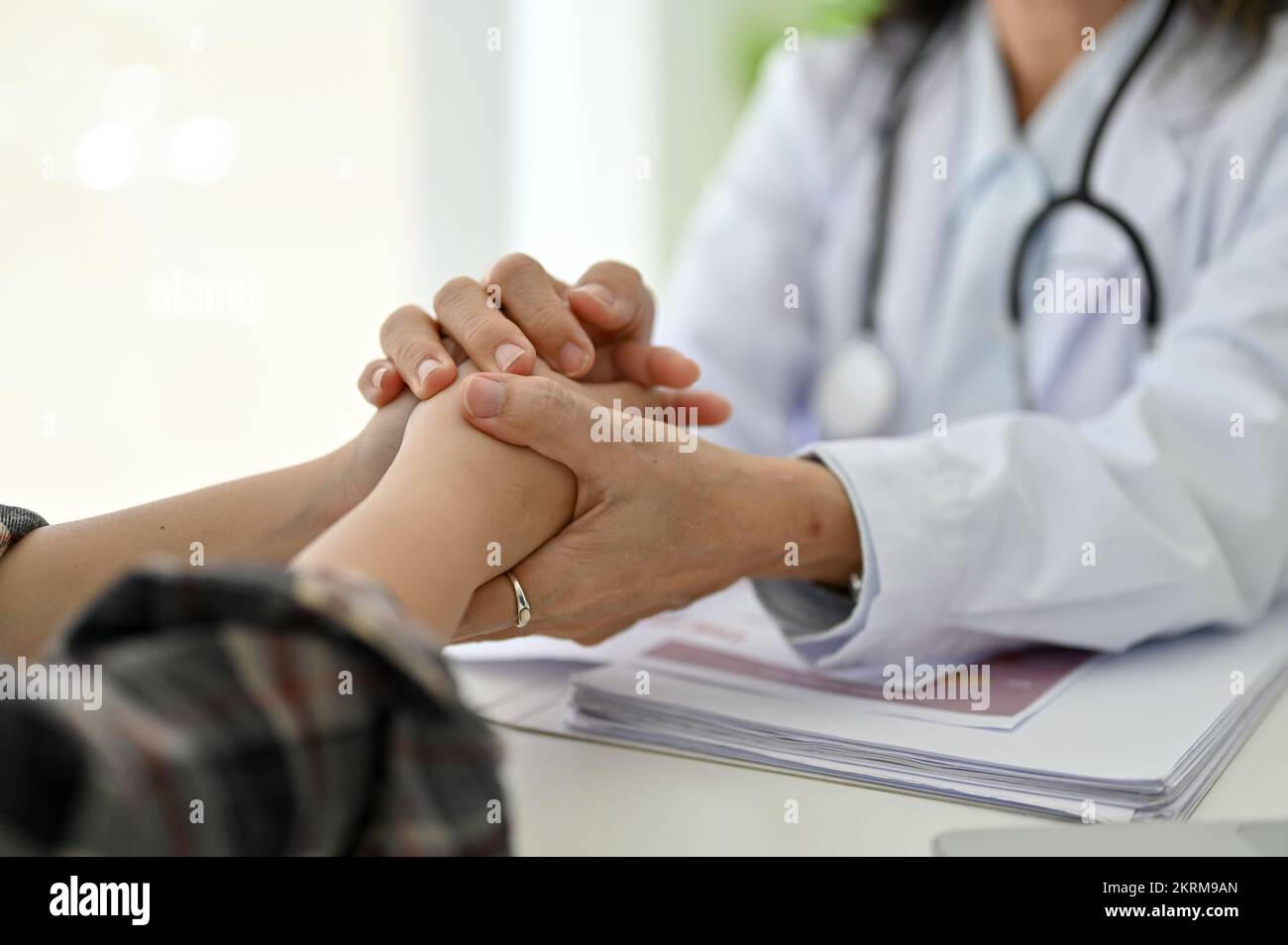 Professional and peaceful Asian senior female doctor holds her young ...