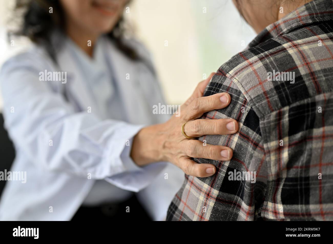 Professional and peaceful Asian senior female doctor touches her young ...