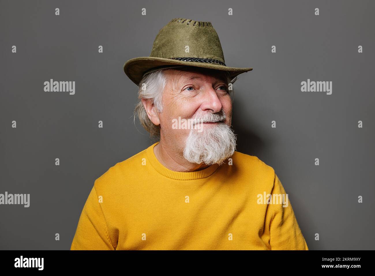 Portrait of gray haired aged male with wrinkles in green cowboy hat and ...