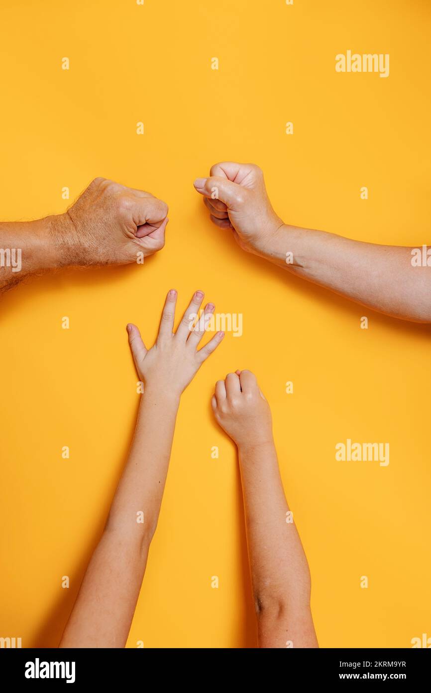 Top view of anonymous aged peoples and kids hands clenched in fists and ...