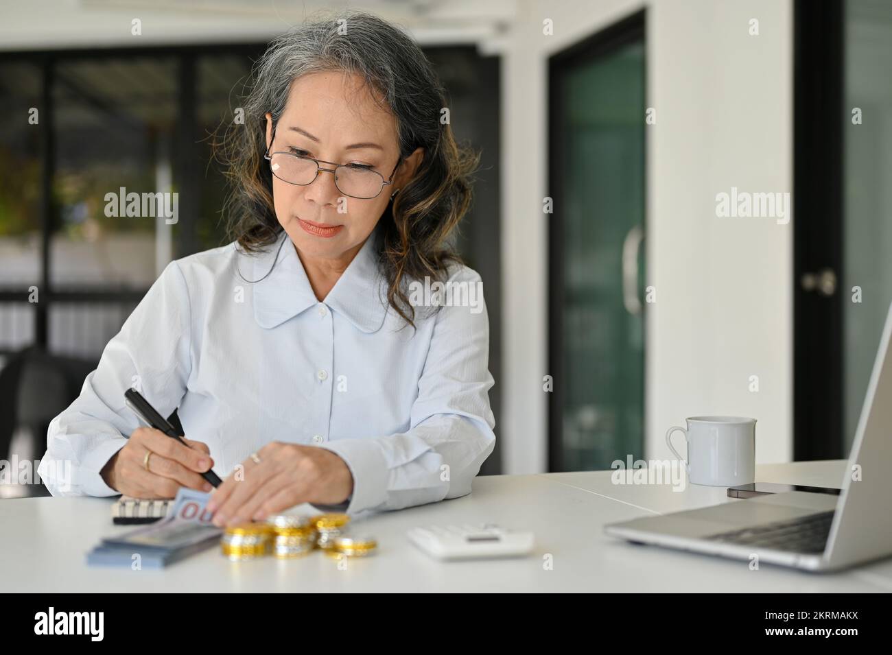 Professional Asian senior female accountant managing project budget ...