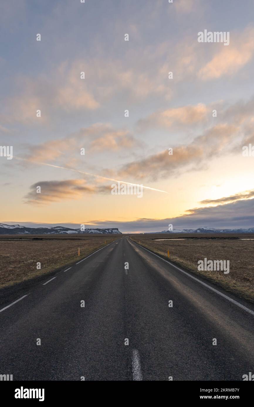 Perspective view of empty asphalt road going through field with dry ...