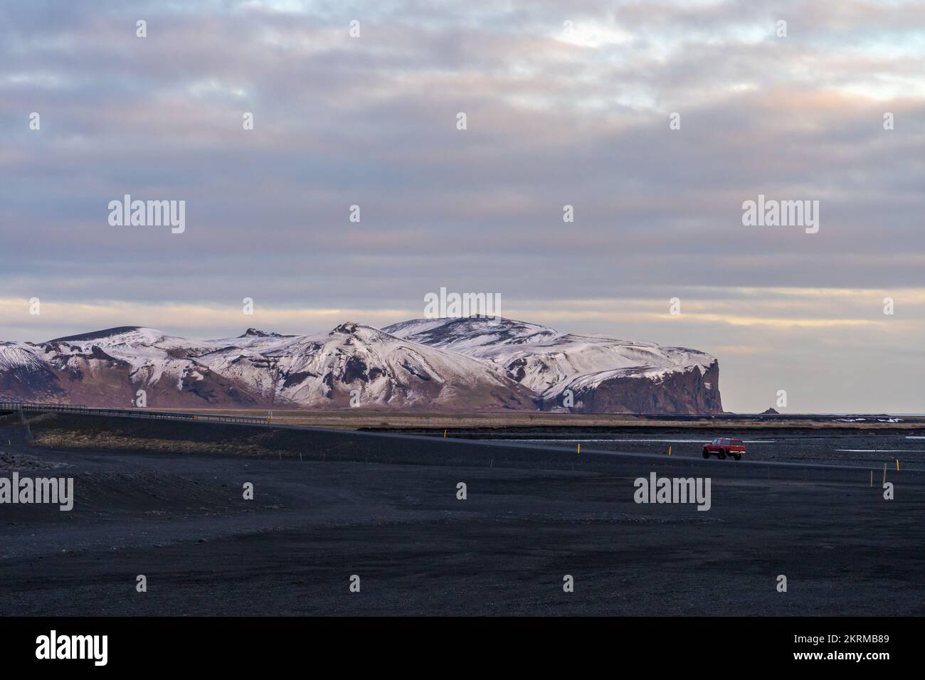 Picturesque view of black sand beach with mountain in distance under ...