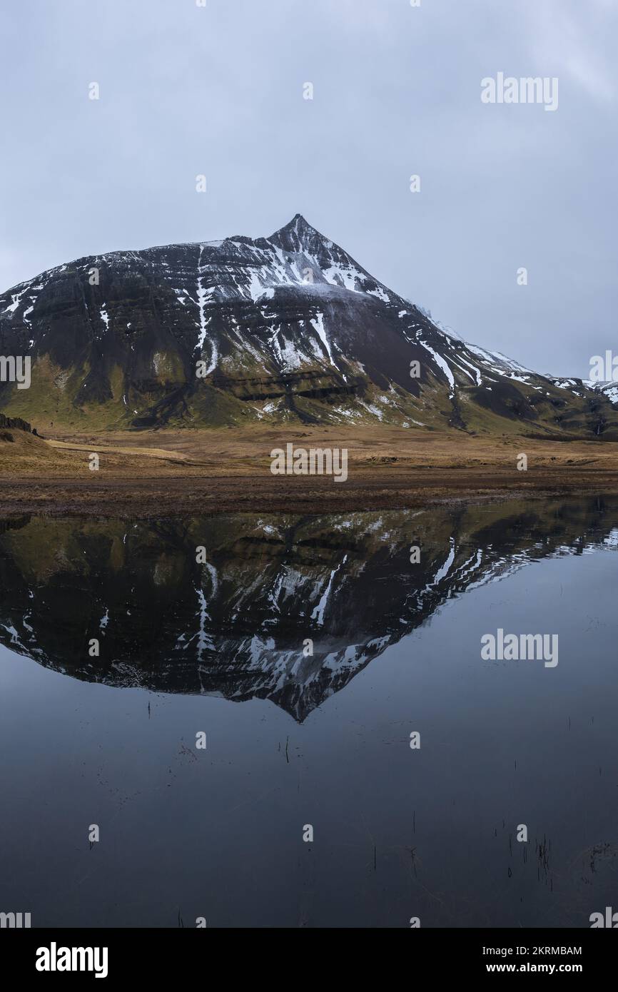 Crystal water of cold lake reflecting huge mountains covered with snow ...