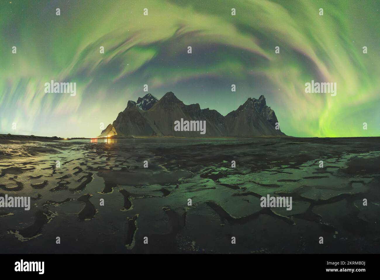 Breathtaking polar light shining over rough stony formation near icy ...