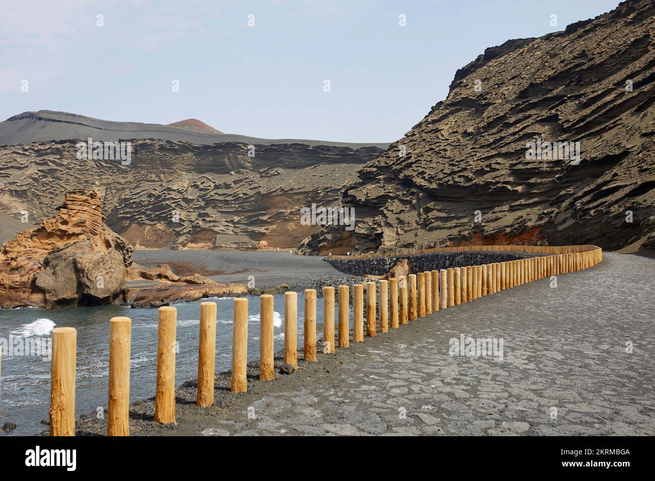 Pathway with wooden fence near rocky mountain and ocean in Green Lake ...