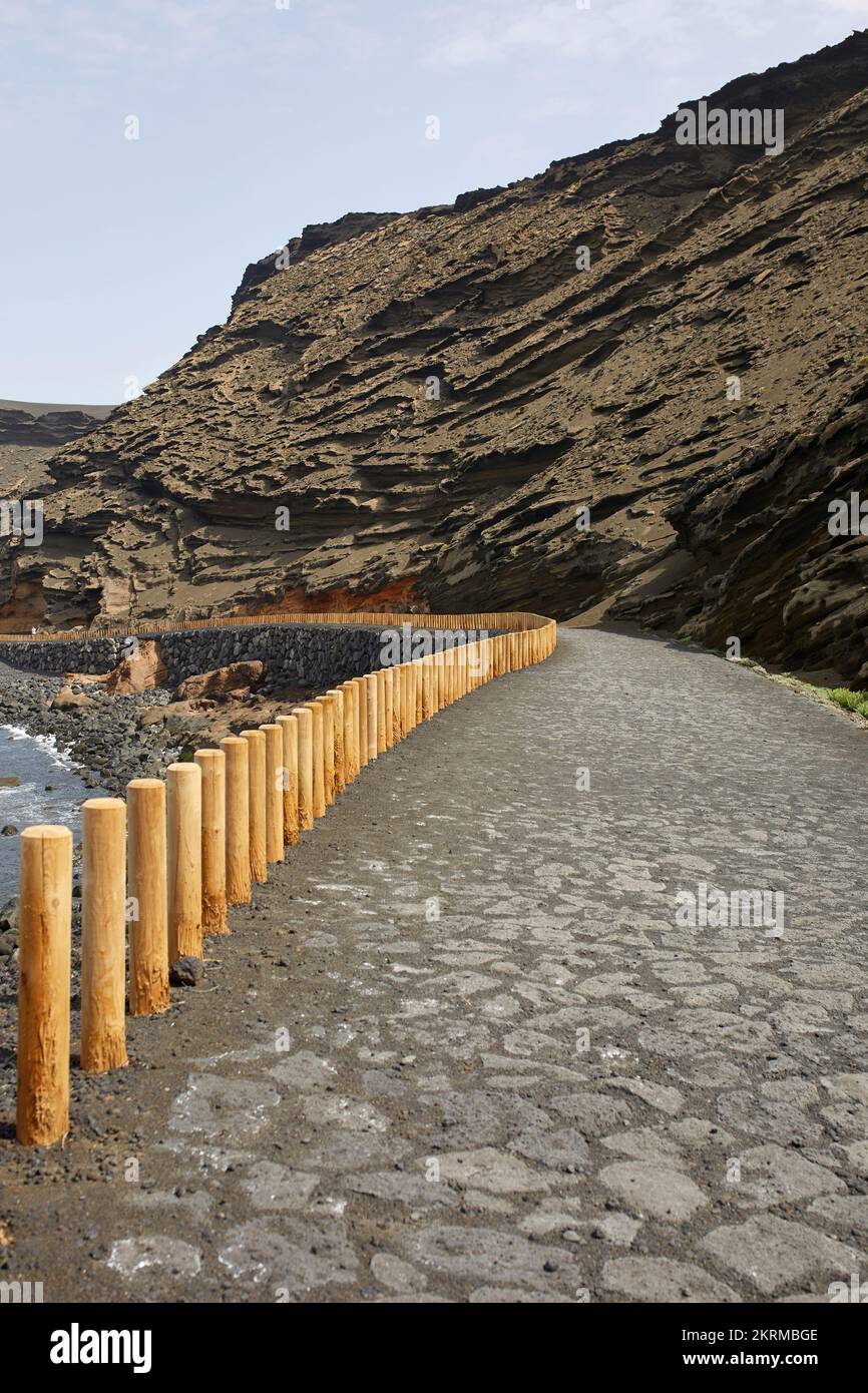 Pathway with wooden fence near rocky mountain and ocean in Green Lake ...