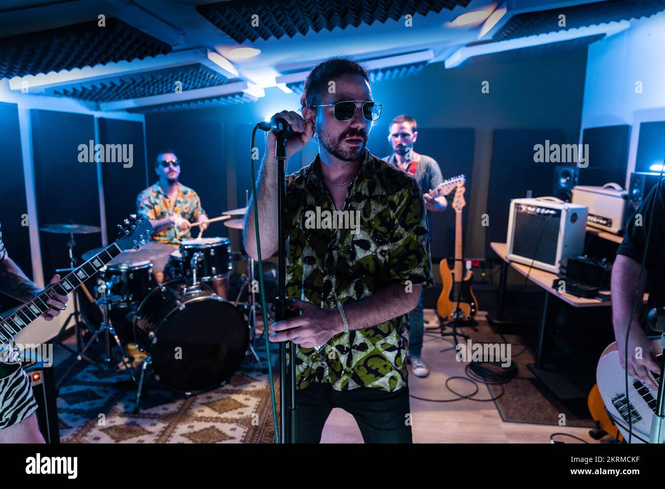 Group of musicians rehearsing song playing electric guitars and drums ...