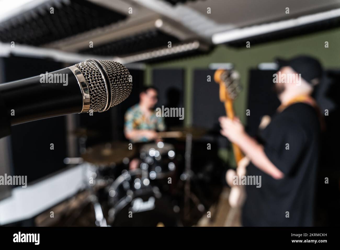 Soft focus of microphone placed in garage while band playing music on ...