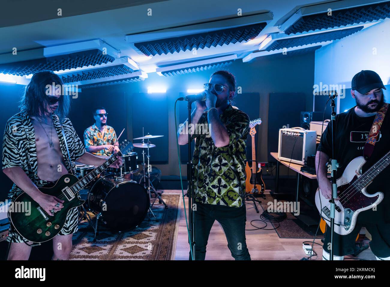 Group of musicians rehearsing song playing electric guitars and drums ...
