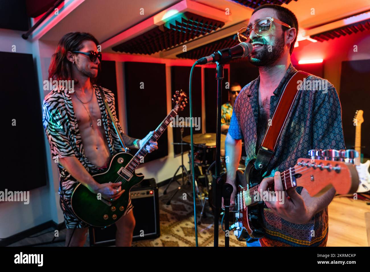 Group of musicians rehearsing song playing electric guitars and drums ...