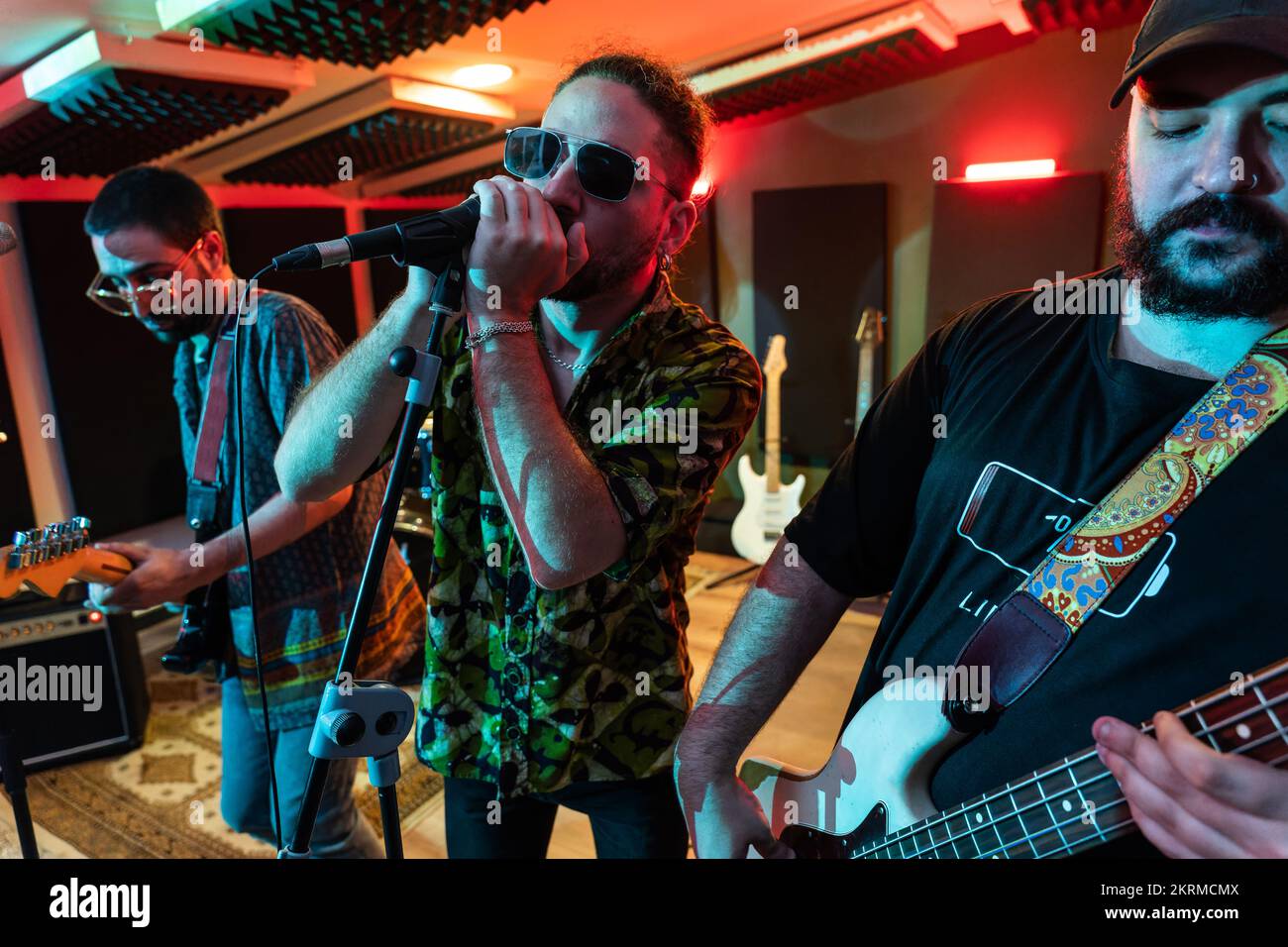 Band singing song into microphones while playing electric guitars ...