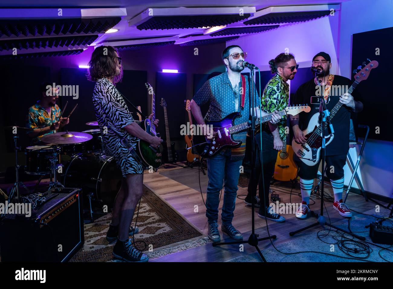 Group of musicians rehearsing song playing electric guitars and drums ...