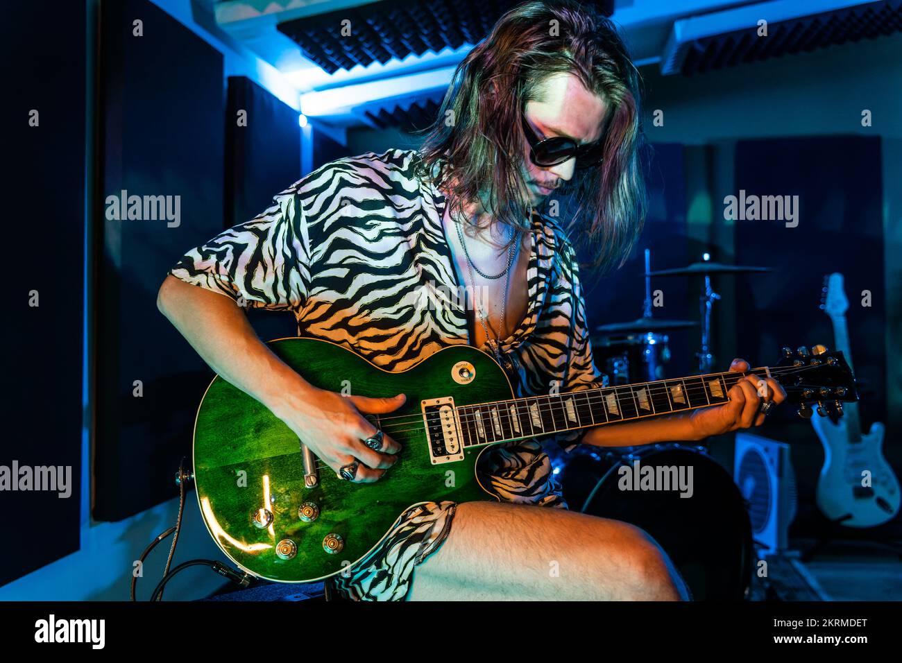 Male musician in zebra print shirt and sunglasses sitting in modern ...