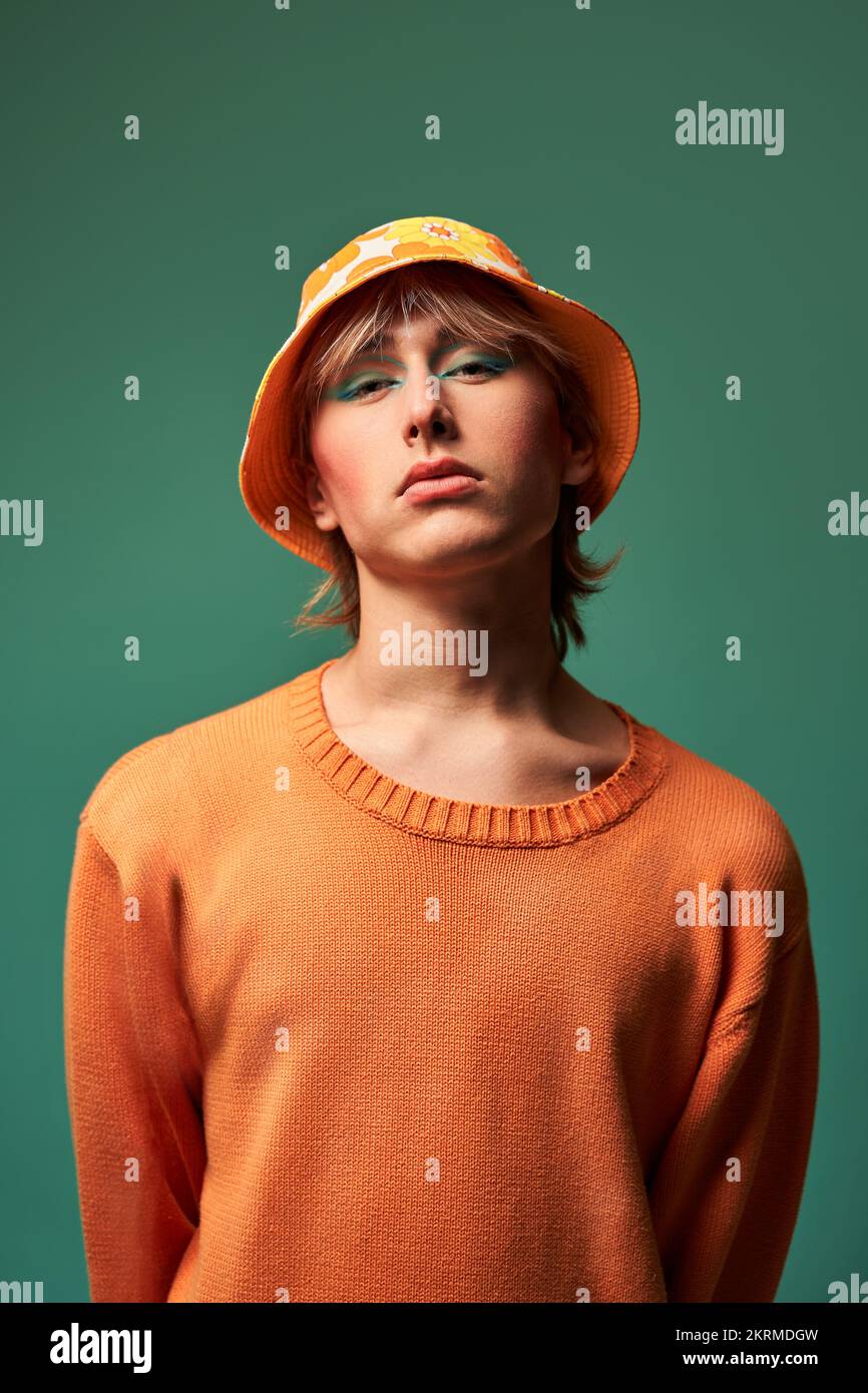 Non binary person in colorful clothes with stylish bag and bucket hat ...