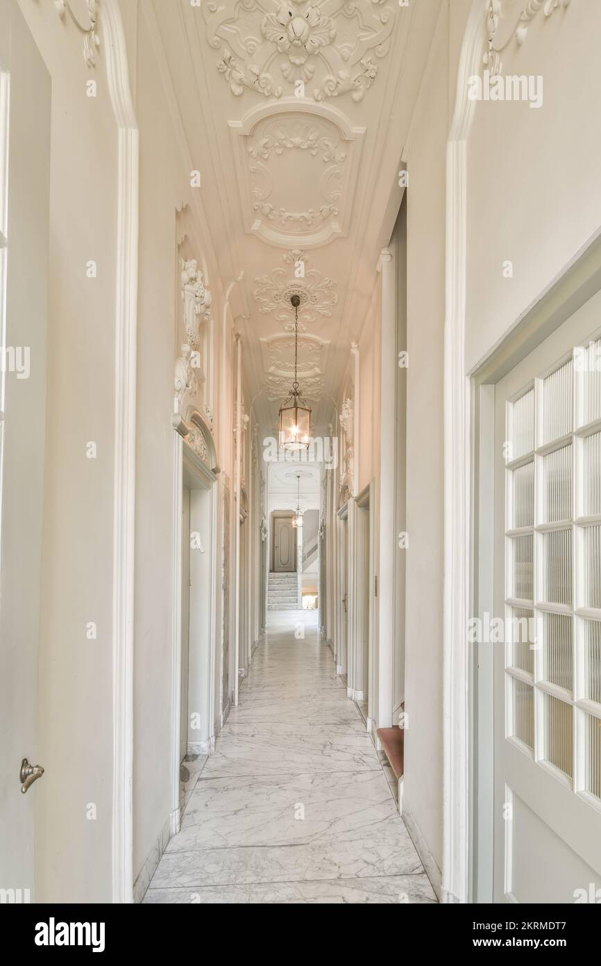 Long corridor with doors and marble floor and various decorative frames ...