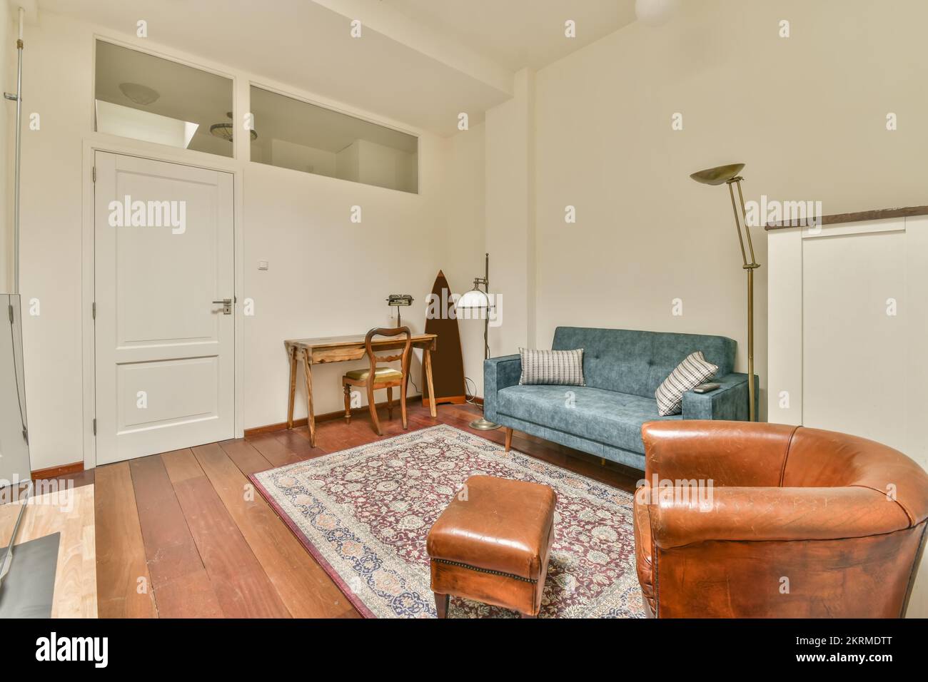 Interior of living room with white wall above comfortable armchair and ...
