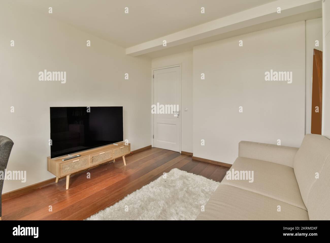 Interior of living room with white wall above comfortable couch and TV ...