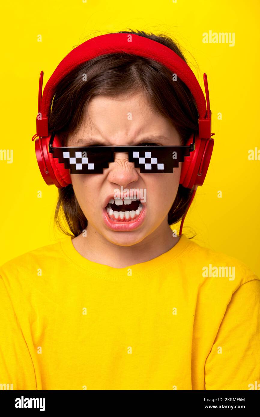 Aggressive girl in red headphones and sweater screaming with anger ...