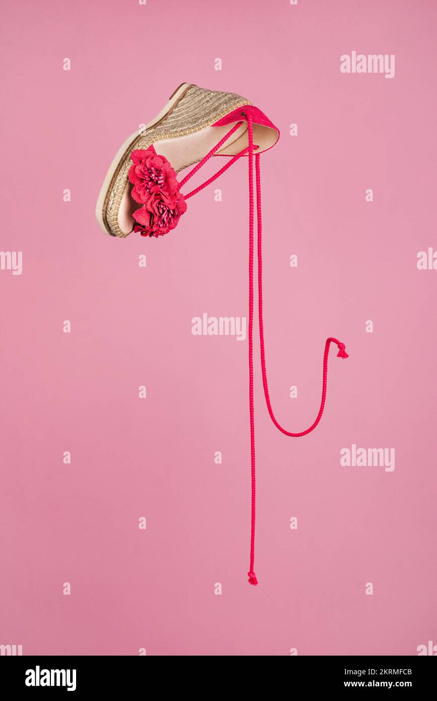 Stylish sandal with flower decorations and shoelaces levitating against ...