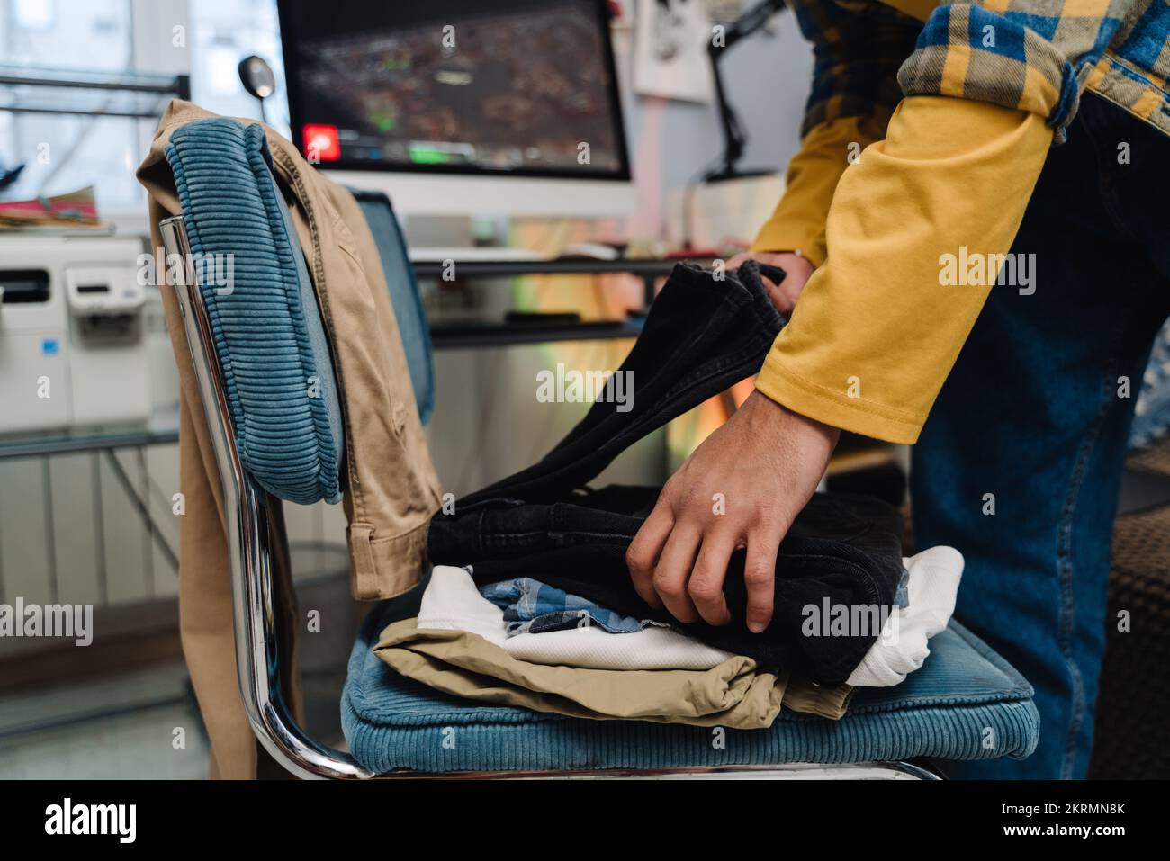 Teenage boy folding his clothes while cleaning bedroom at home Stock ...