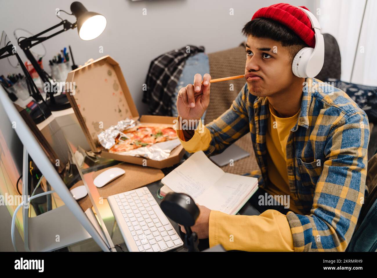 Middle-eastern teenage boy using desktop computer while studying at ...