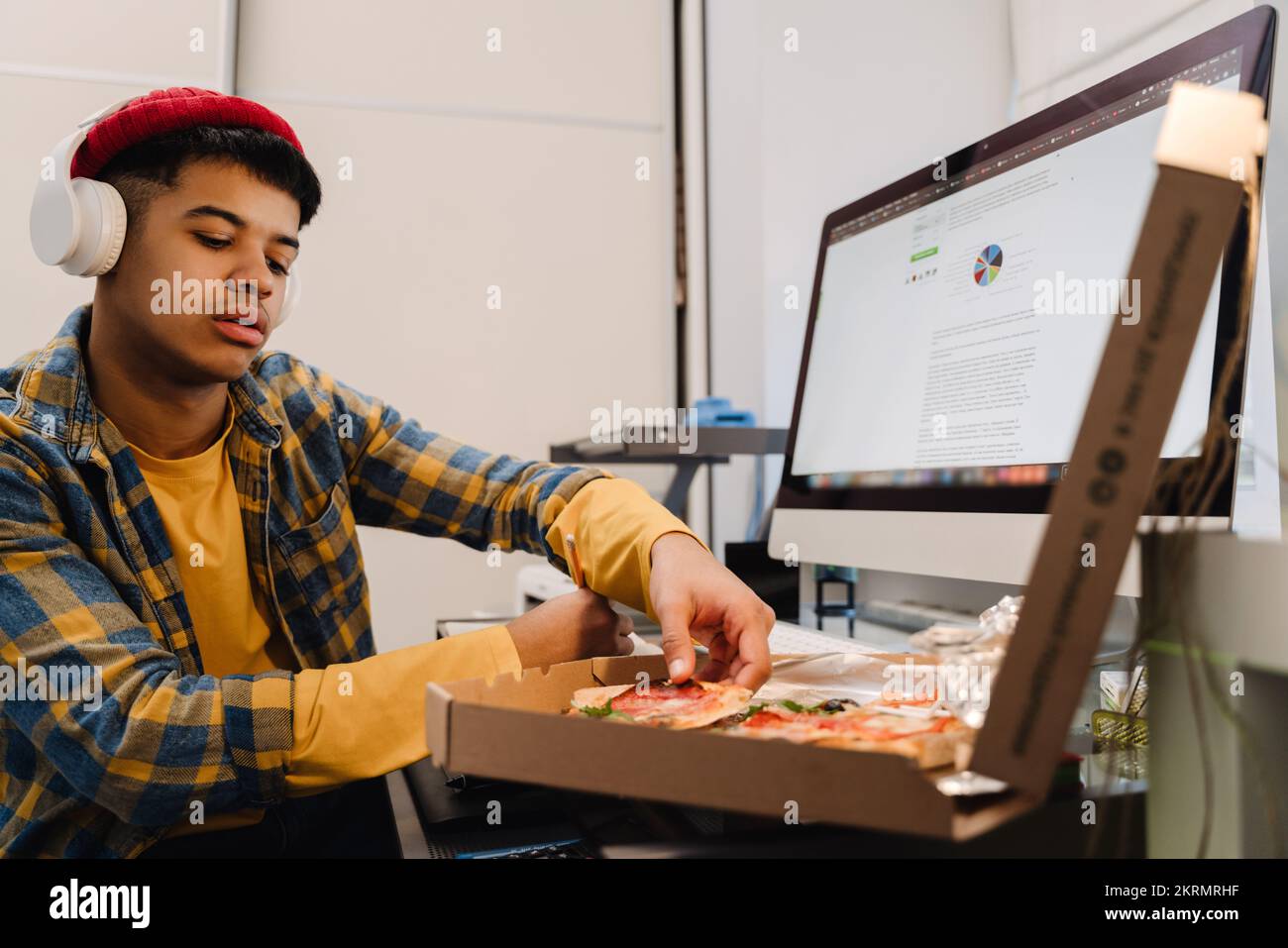 Middle-eastern teenage boy using desktop computer while studying at ...