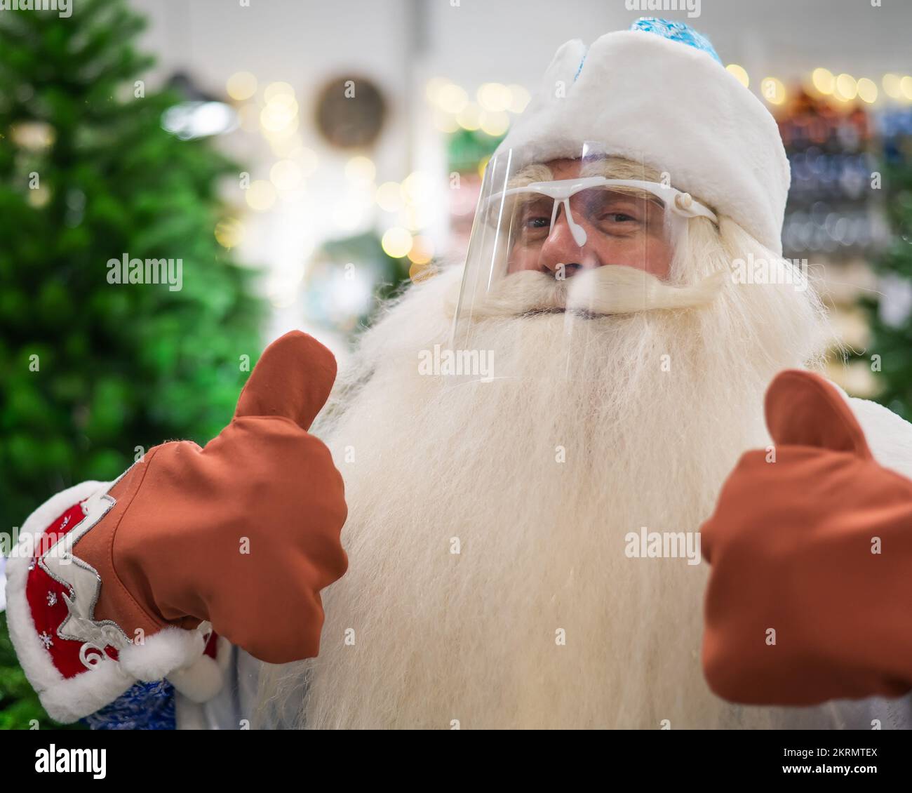 Portrait of Russian santa claus wearing a protective visor shows thumbs ...