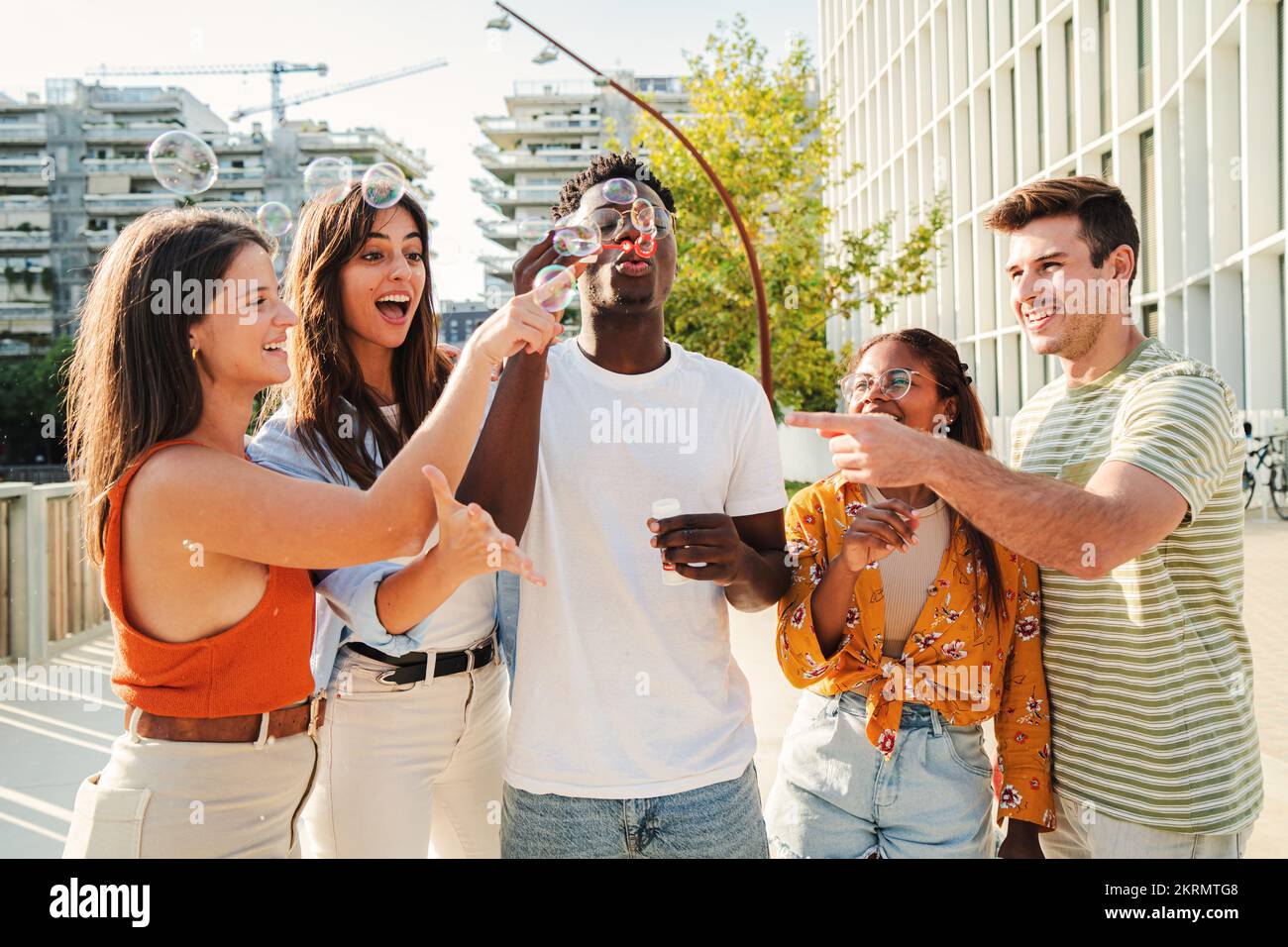 Multiethnic smiling group of teens blowing bubble soup and enjoying ...