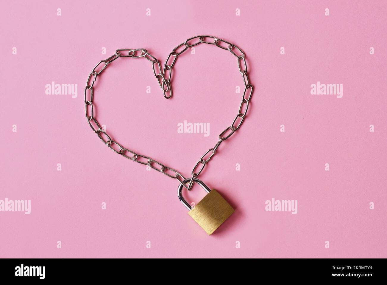Heart made of chain with padlock on pink background - Love and freedom ...