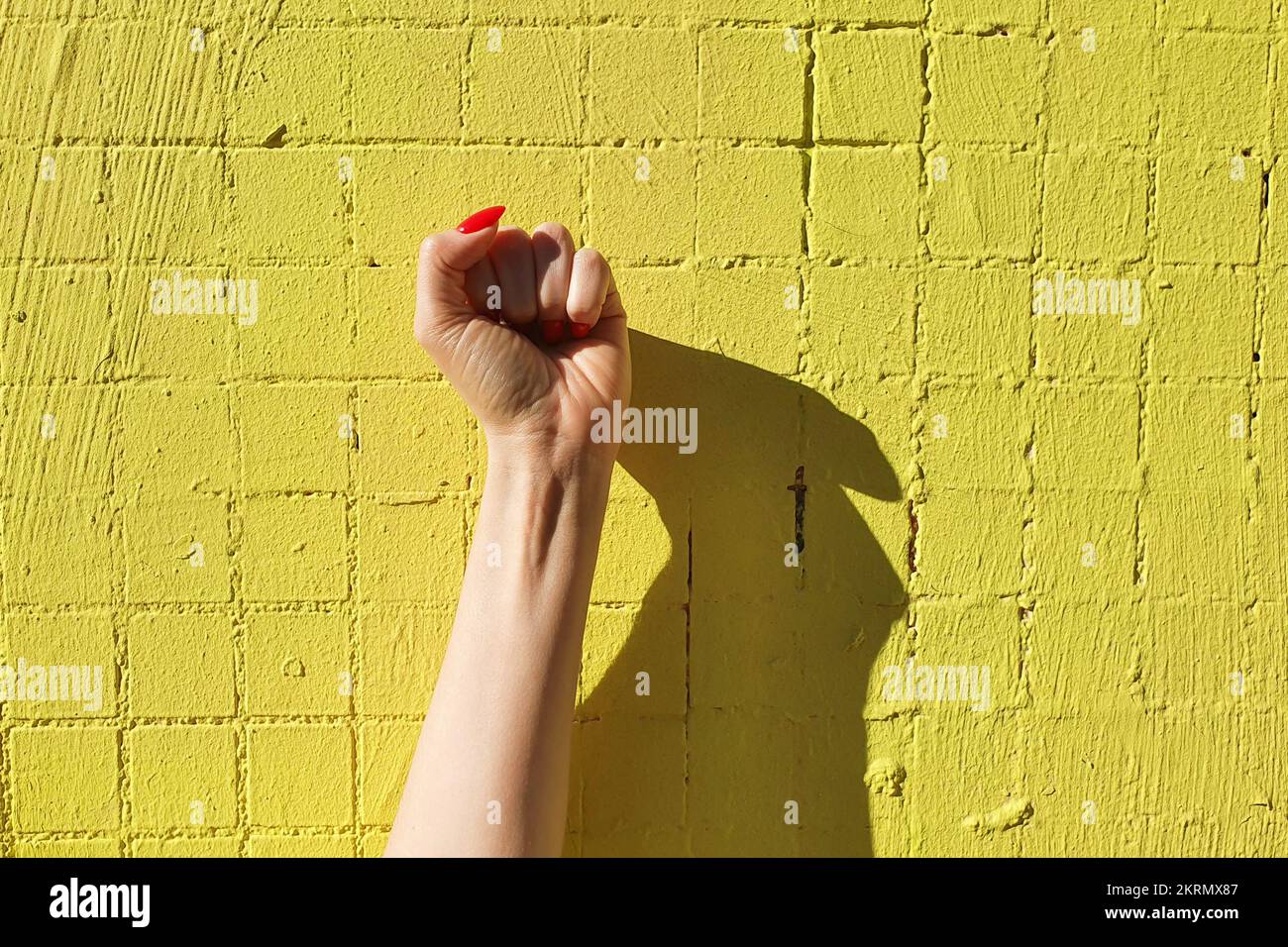 Woman's female fist hand with red nails, fist punch air with shadow on ...