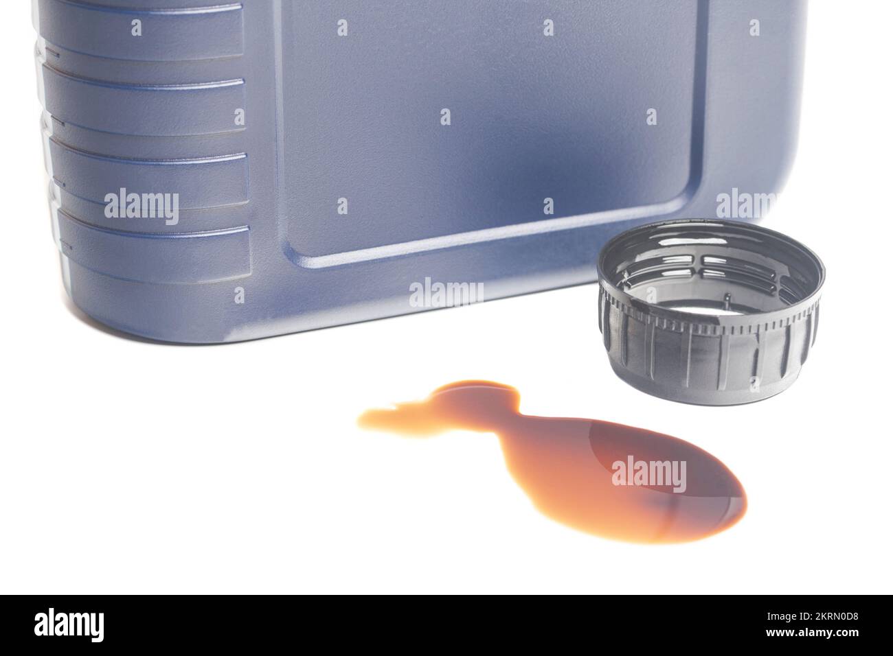 open engine oil bottle with a puddle of engine oil isolated on white ...