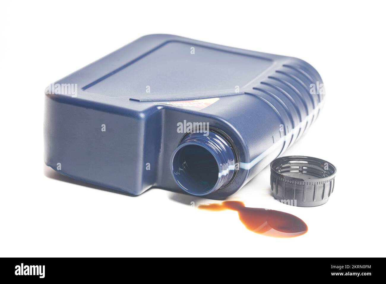 open engine oil bottle with a puddle of engine oil isolated on white ...