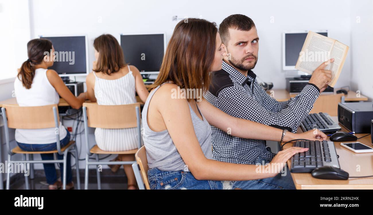 Students reading textbook in computer class Stock Photo - Alamy