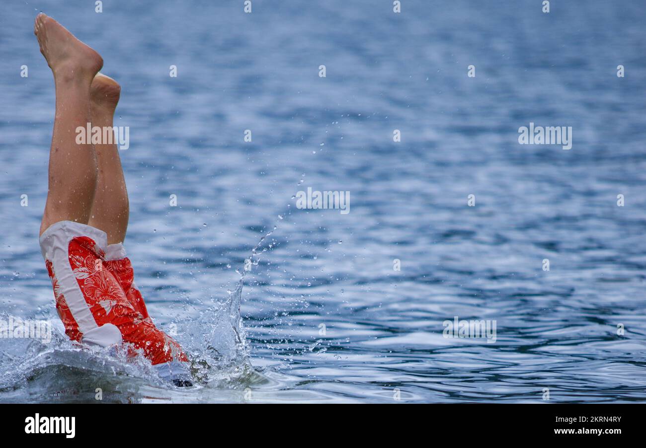 Diving in, only the divers feet are dry Stock Photo - Alamy