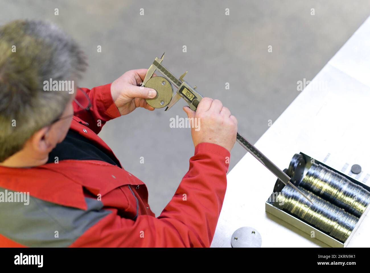 industrial workers inspect work piece for accuracy with measuring ...