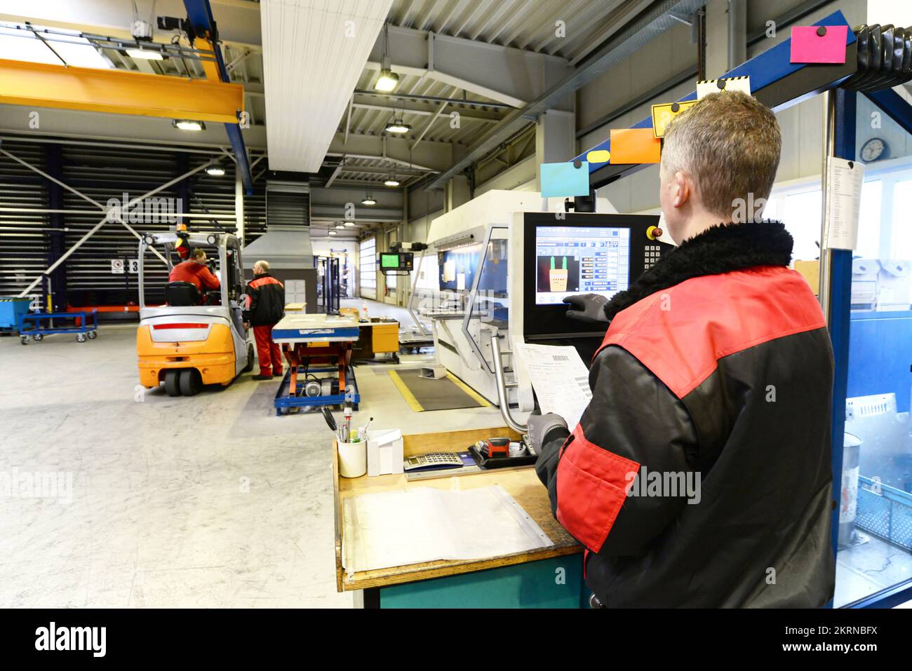 industrial worker operates a sheet metal bending machine - company for ...