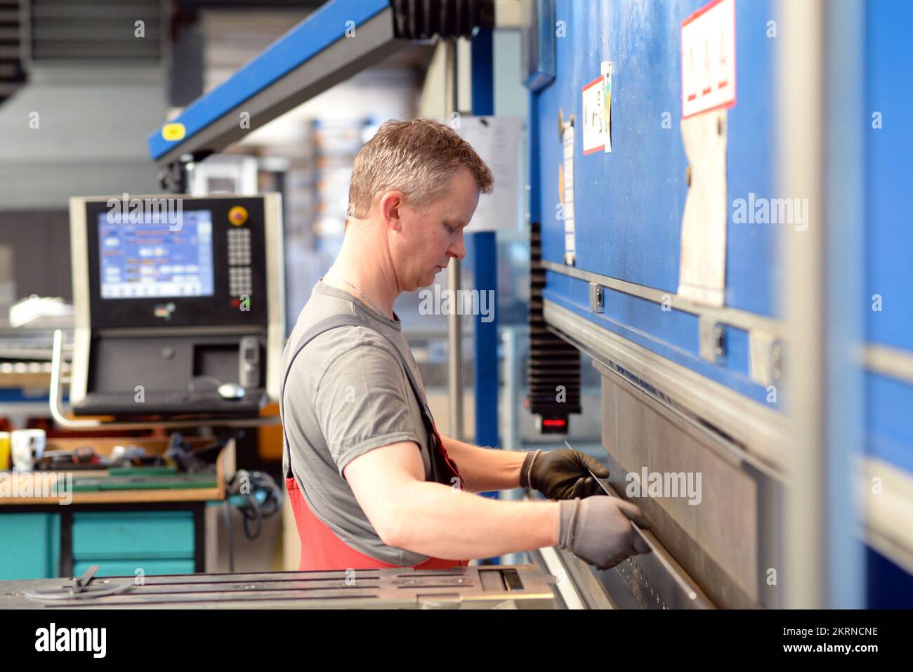 employee operates bending machine in a metalworking company - bending ...