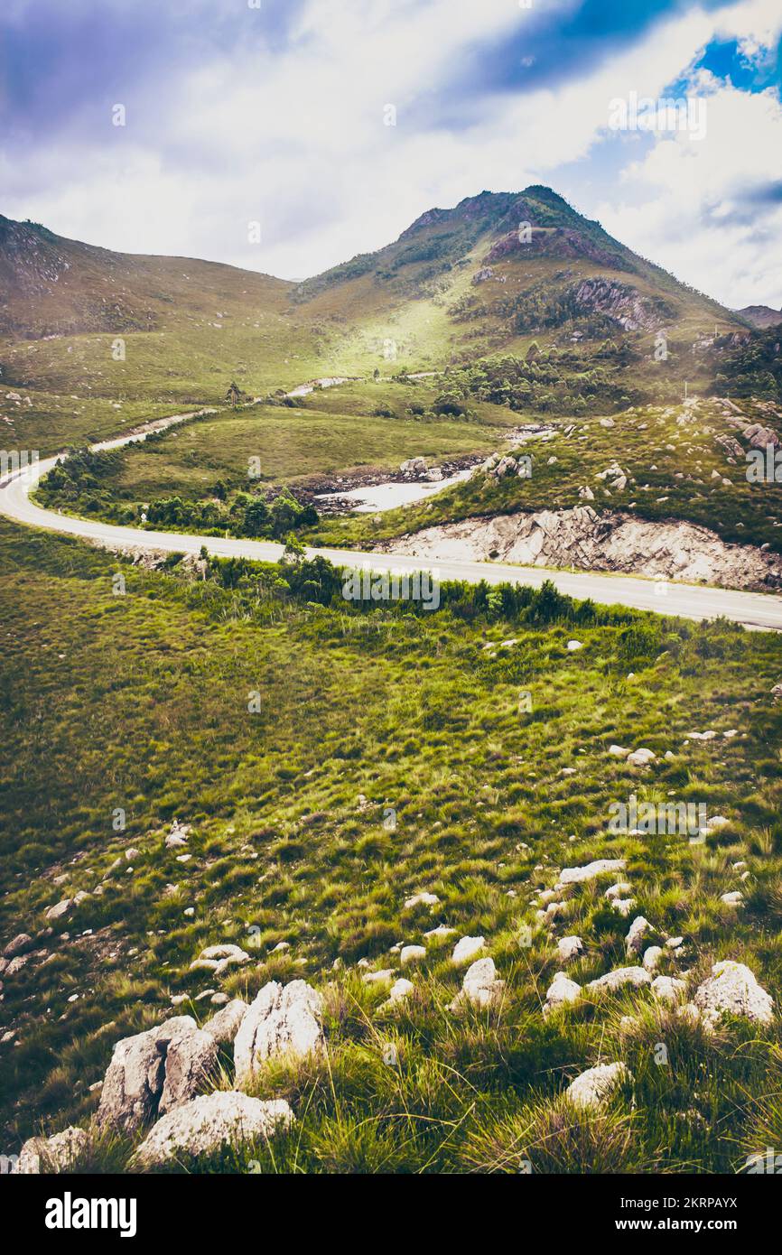 Cloudy vertical landscape scene of rocky mountain terrain wrapping ...