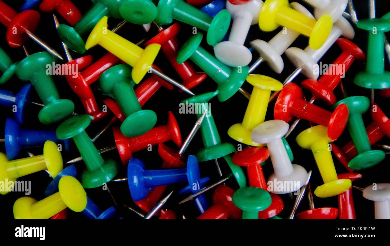 colorful thumbtacks on black background Stock Photo - Alamy