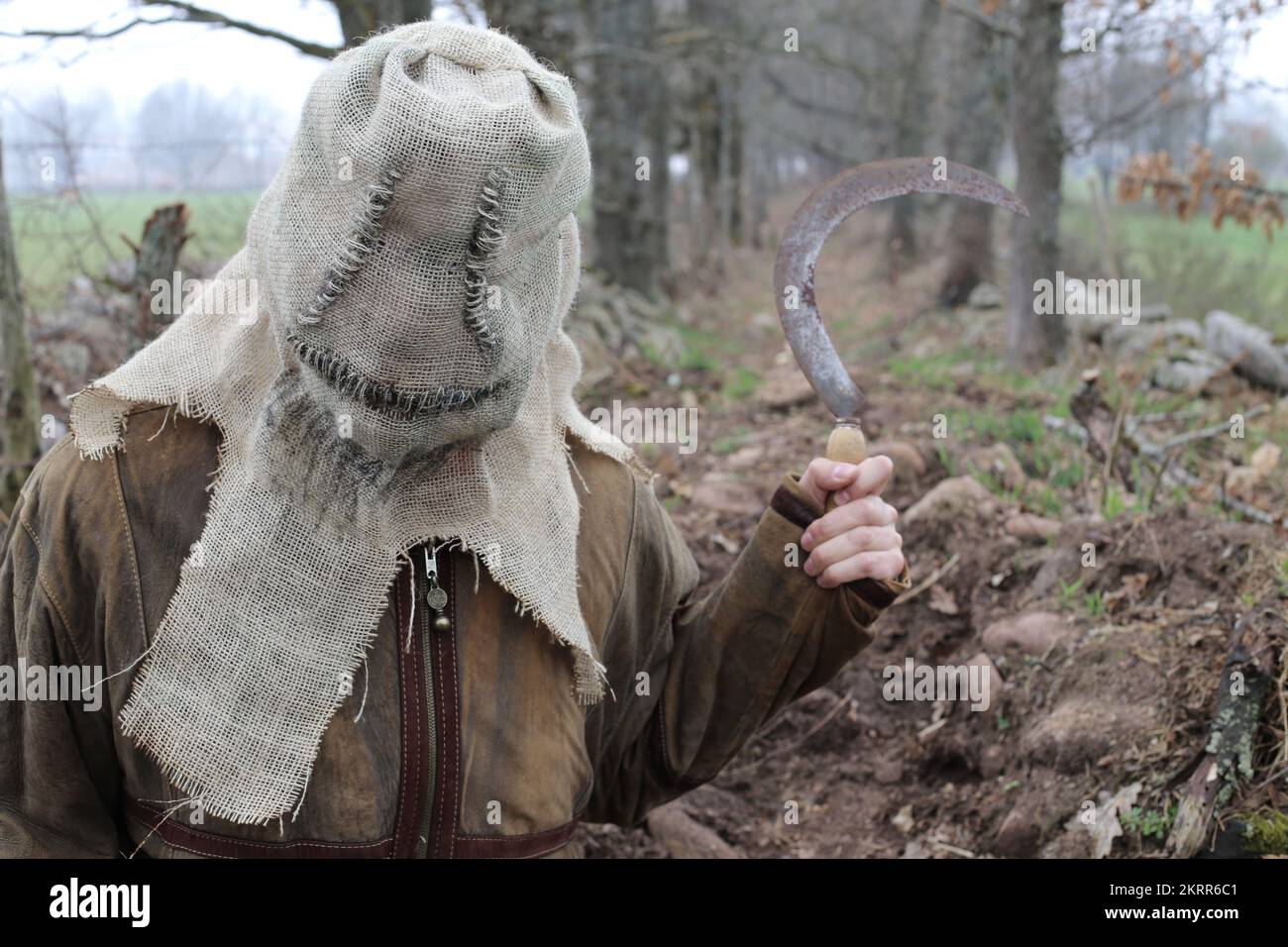 Spooky masked man in cemetery entrance Stock Photo - Alamy