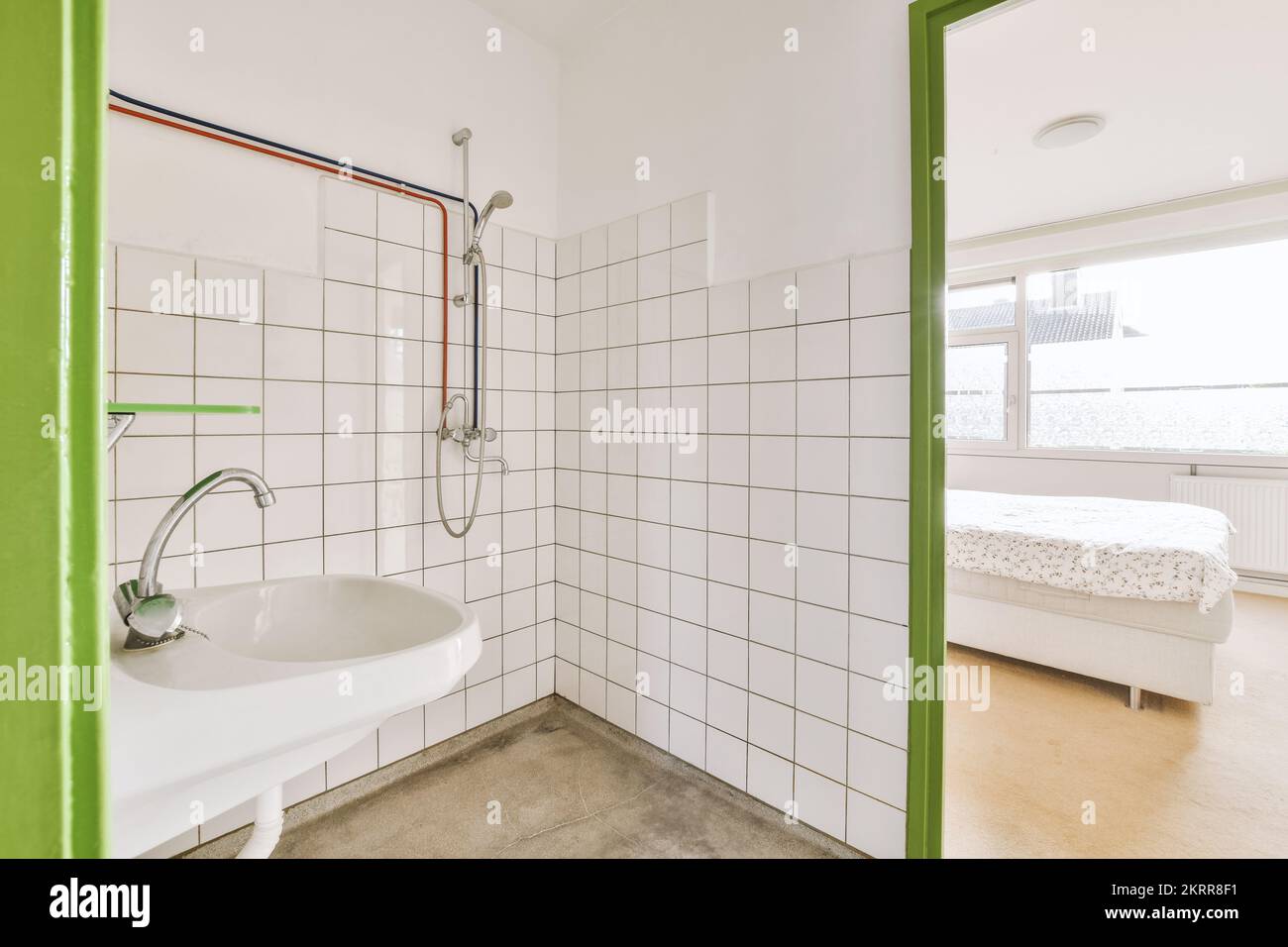 Cupboard with sink and mirror attached to tiled wall near door and ...