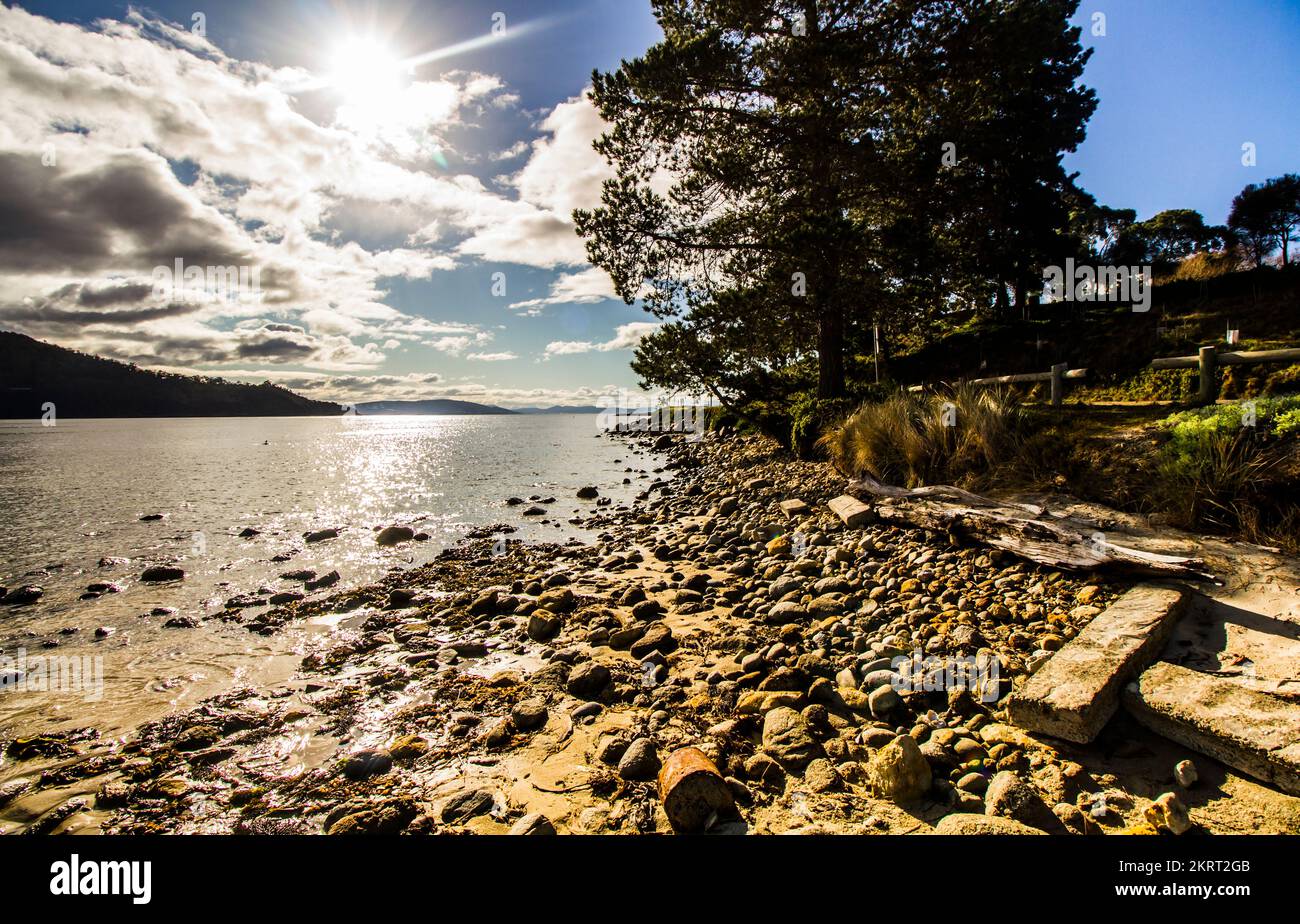 Sunny harbour view of stones scattering the coastline of the Northern ...