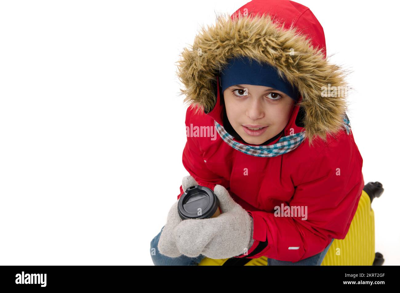 Handsome traveler boy in red parka, warms his hands with hot drink in ...