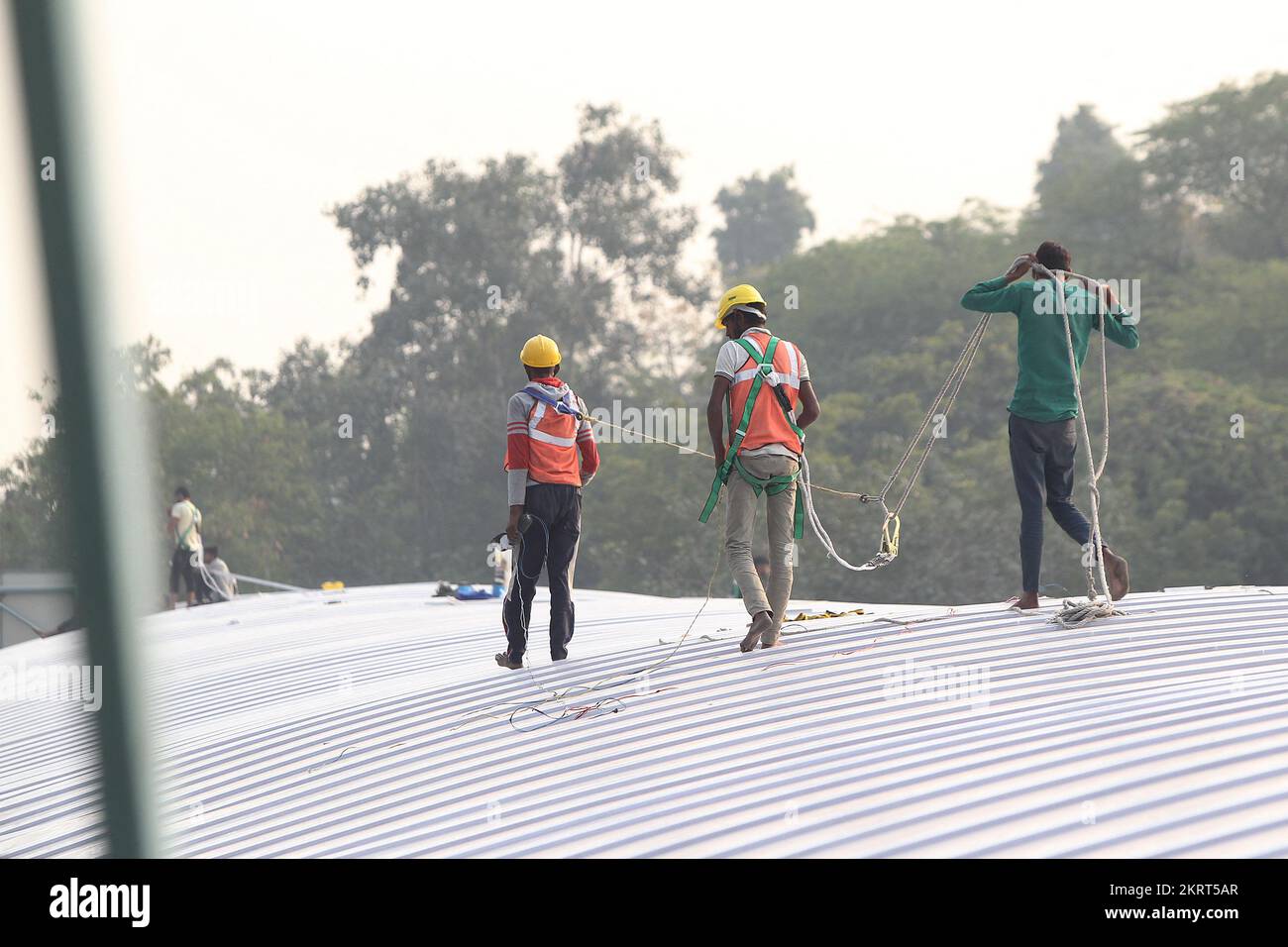 Labourers cut metal girders with safety measures at an under ...